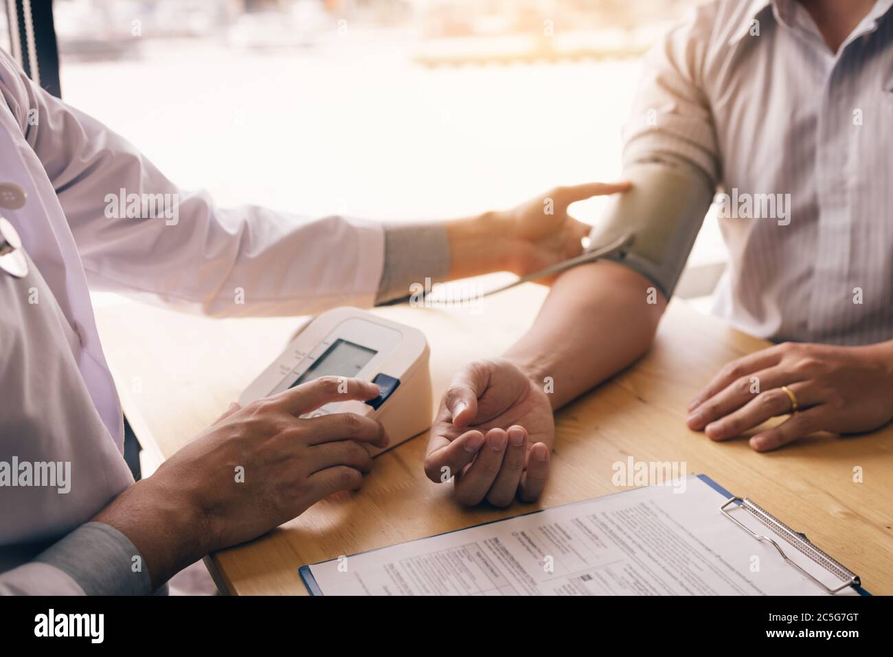 Doctor is using a pulse meter to measure the pressure of the patient at ...