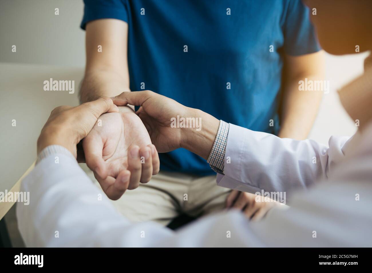 Physical therapist checks the patient wrist by pressing the wrist bone ...