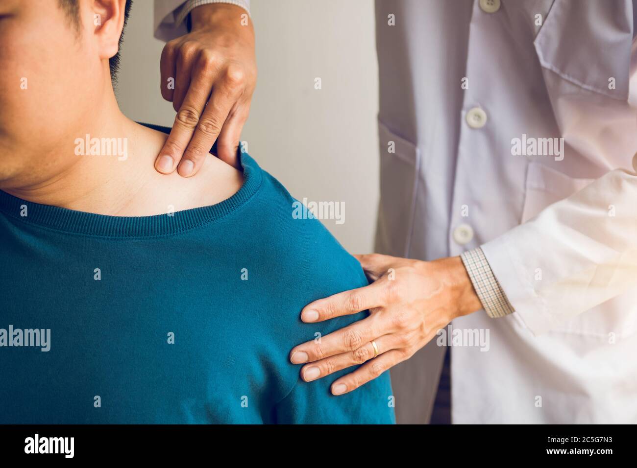 Physical therapists are using their hands to press the clavicle of the ...