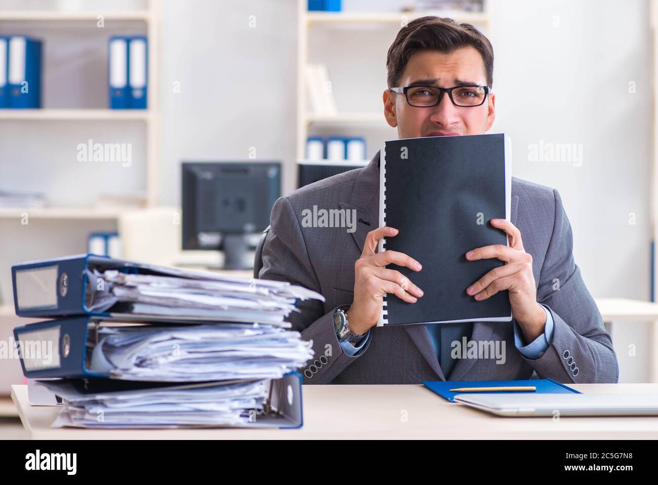 The overloaded with work employee under paperwork burden Stock Photo ...