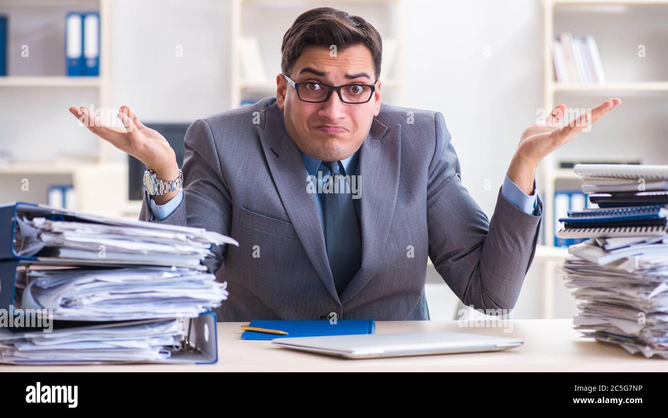 The overloaded with work employee under paperwork burden Stock Photo ...