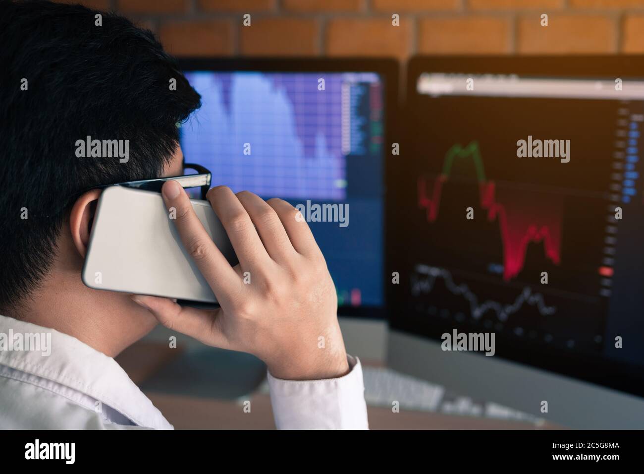 Agent trader man talking at telephone and checking business stock data ...