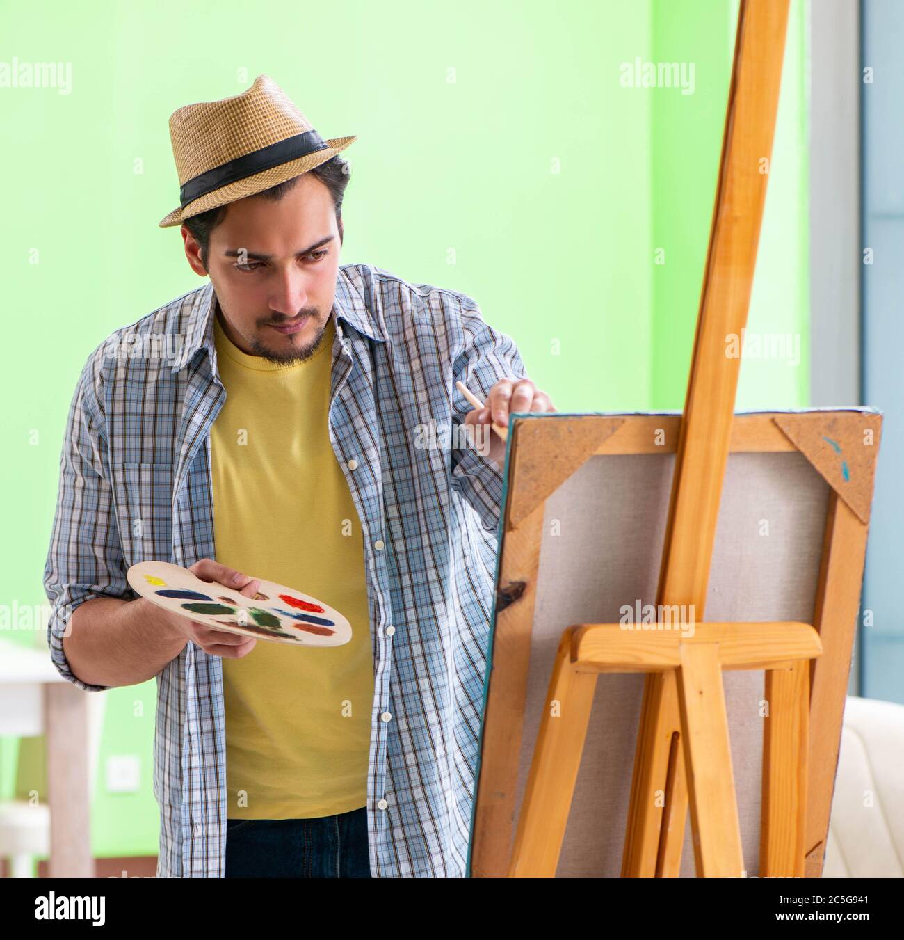 The young male artist working on new painting in his studio Stock Photo ...