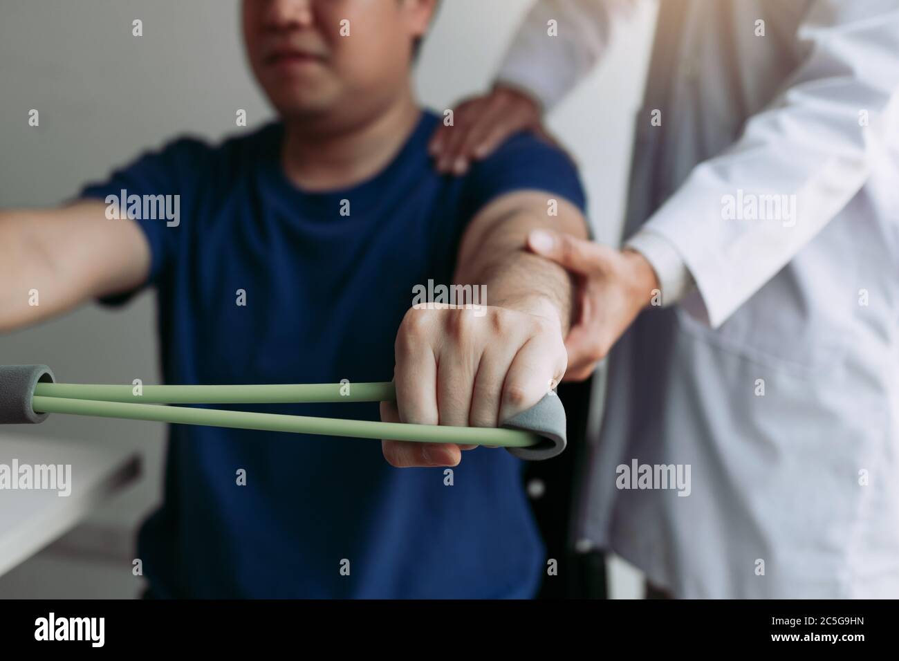 Asian male physical therapist descent working with patient doing ...