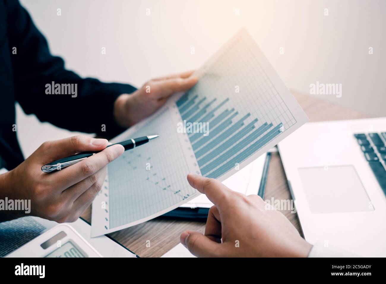Business people discussion about summary report graph and calculation ...