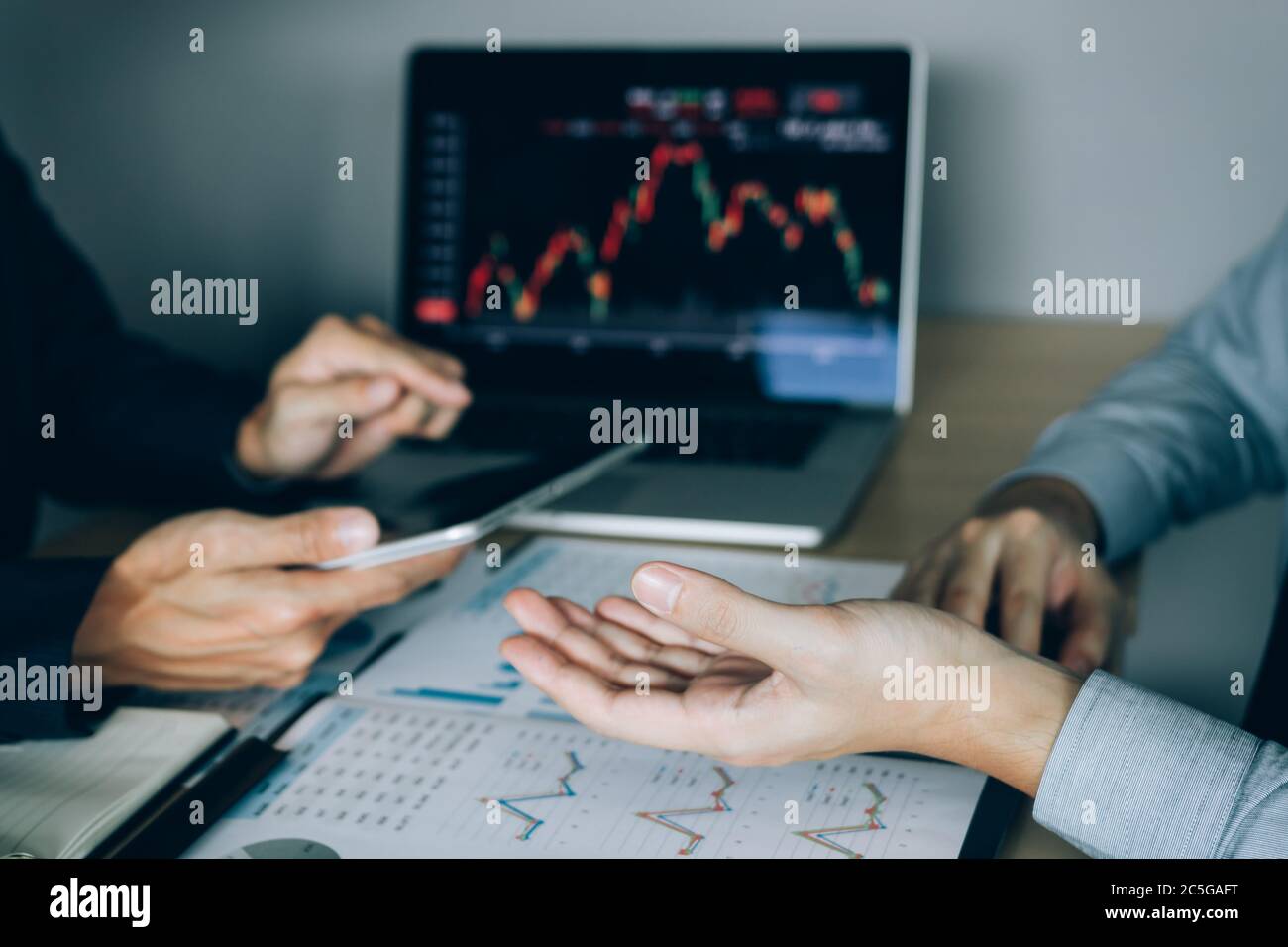 Two investors are working together with analyzing the stock data graphs ...