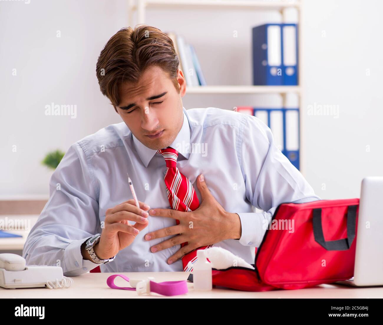 The man with first aid kit in the office Stock Photo - Alamy
