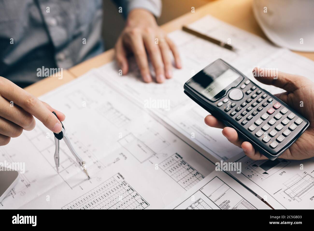 Two architect working at construction site and compass drawing pointing ...