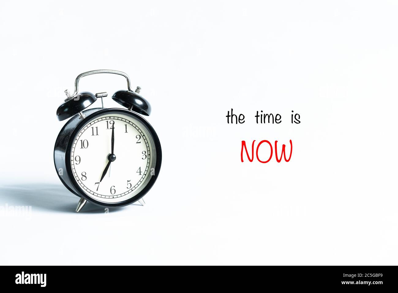 “THE TIME IS NOW” wordings with alarm clock against white background ...