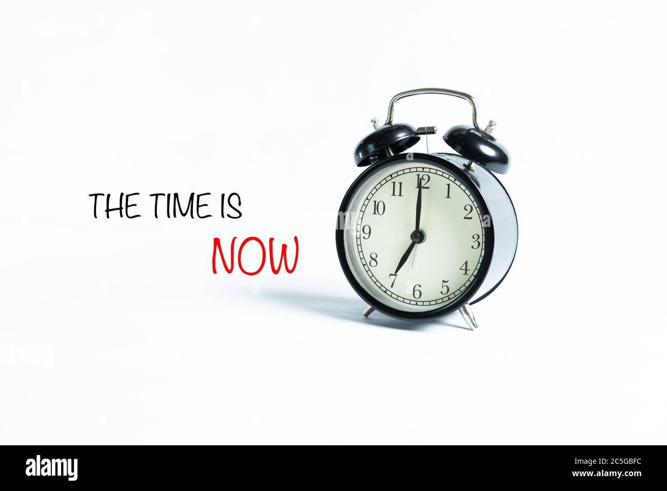 “THE TIME IS NOW” wordings with alarm clock against white background ...