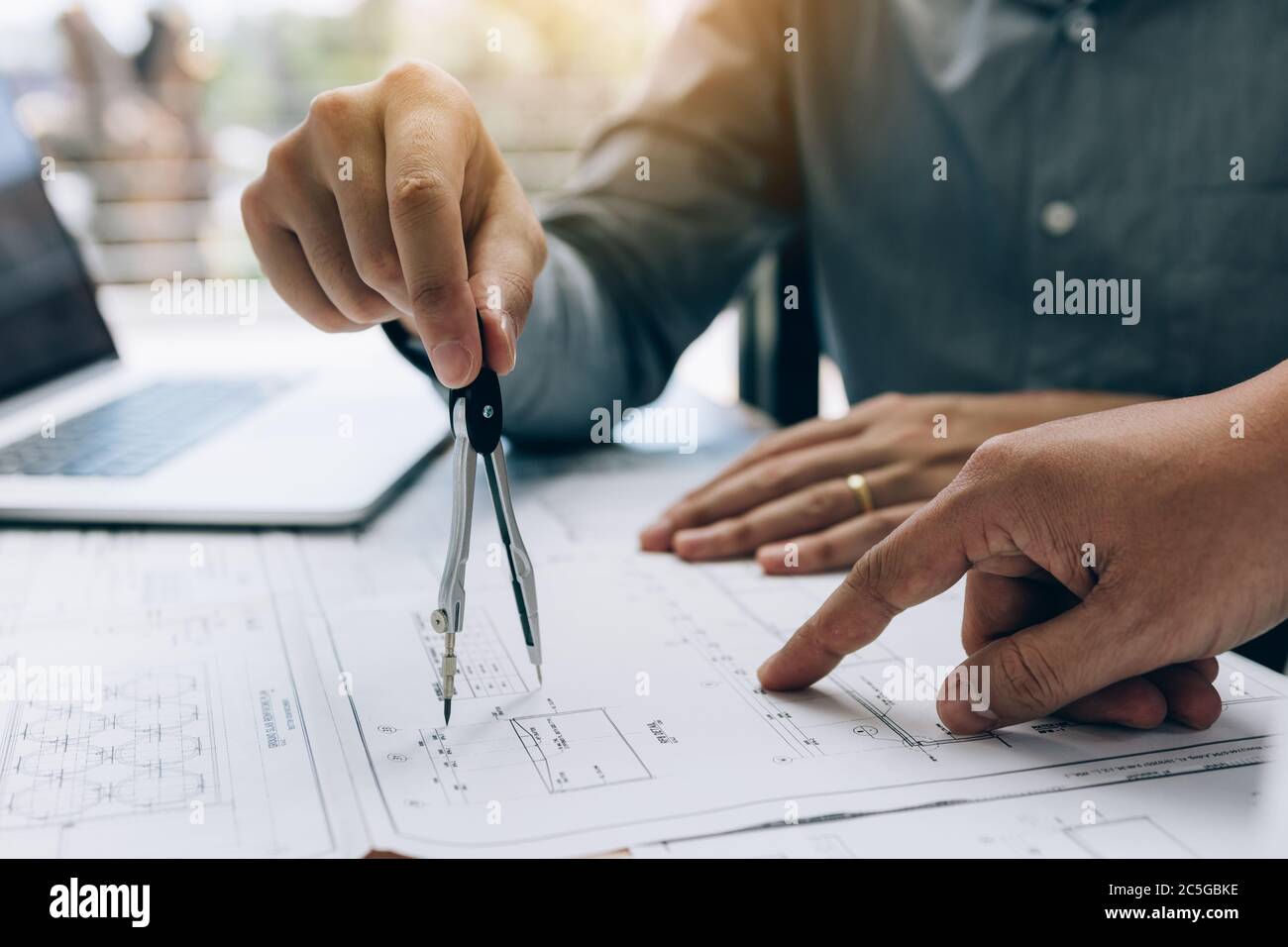 Architect working on blueprint in workplace with partnership and ...