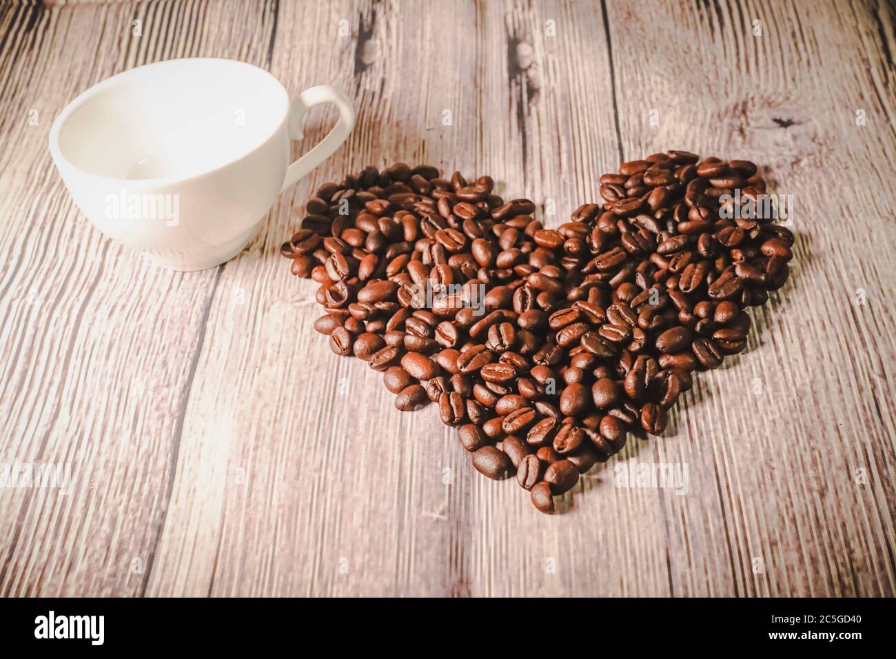 a handful of coffee beans in the shape of a heart, close-up. roasted ...