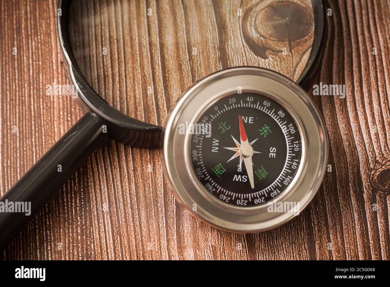 Metallic compass on wooden background Stock Photo - Alamy