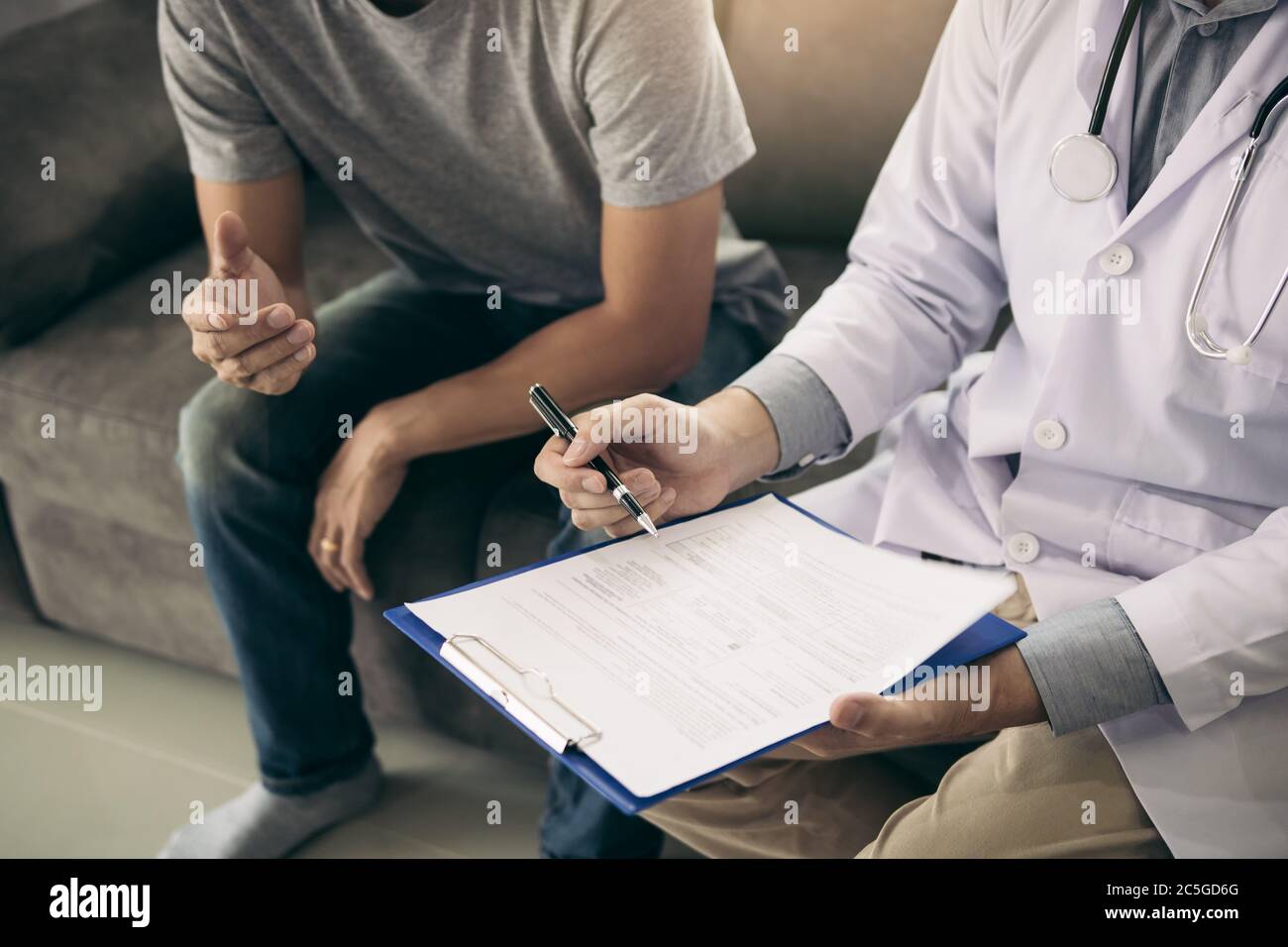 Doctor is recording the patient's information while the patient is ...