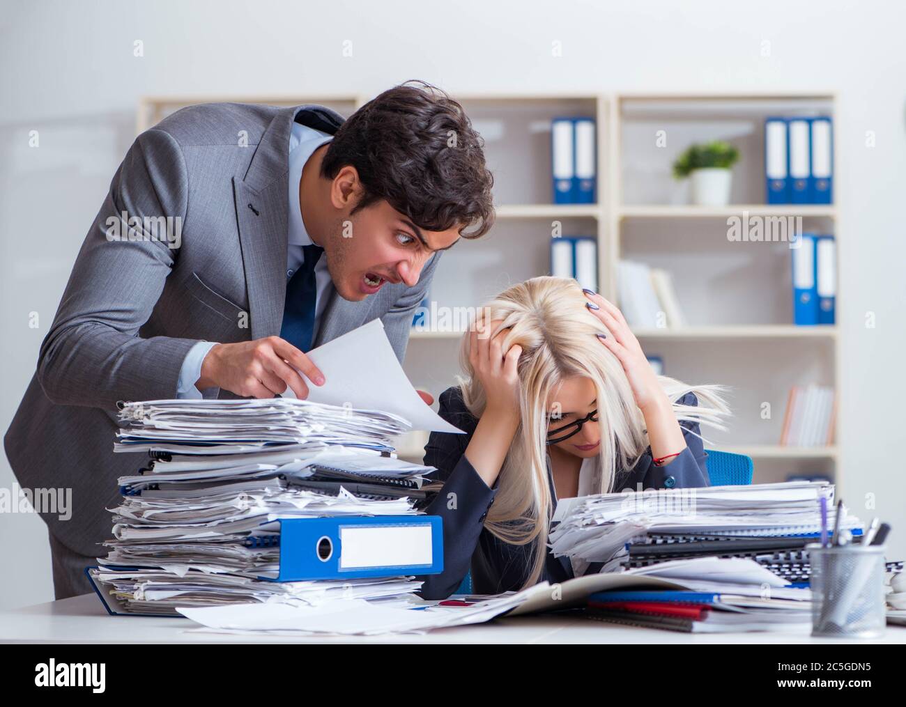 The angry irate boss yelling and shouting at his secretary employee ...
