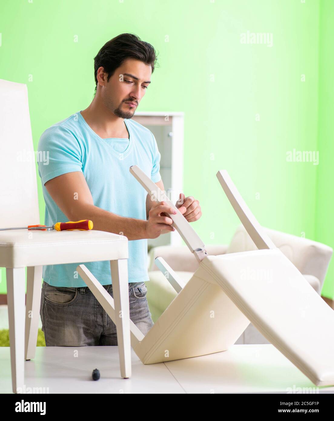 The man repairing furniture at home Stock Photo - Alamy