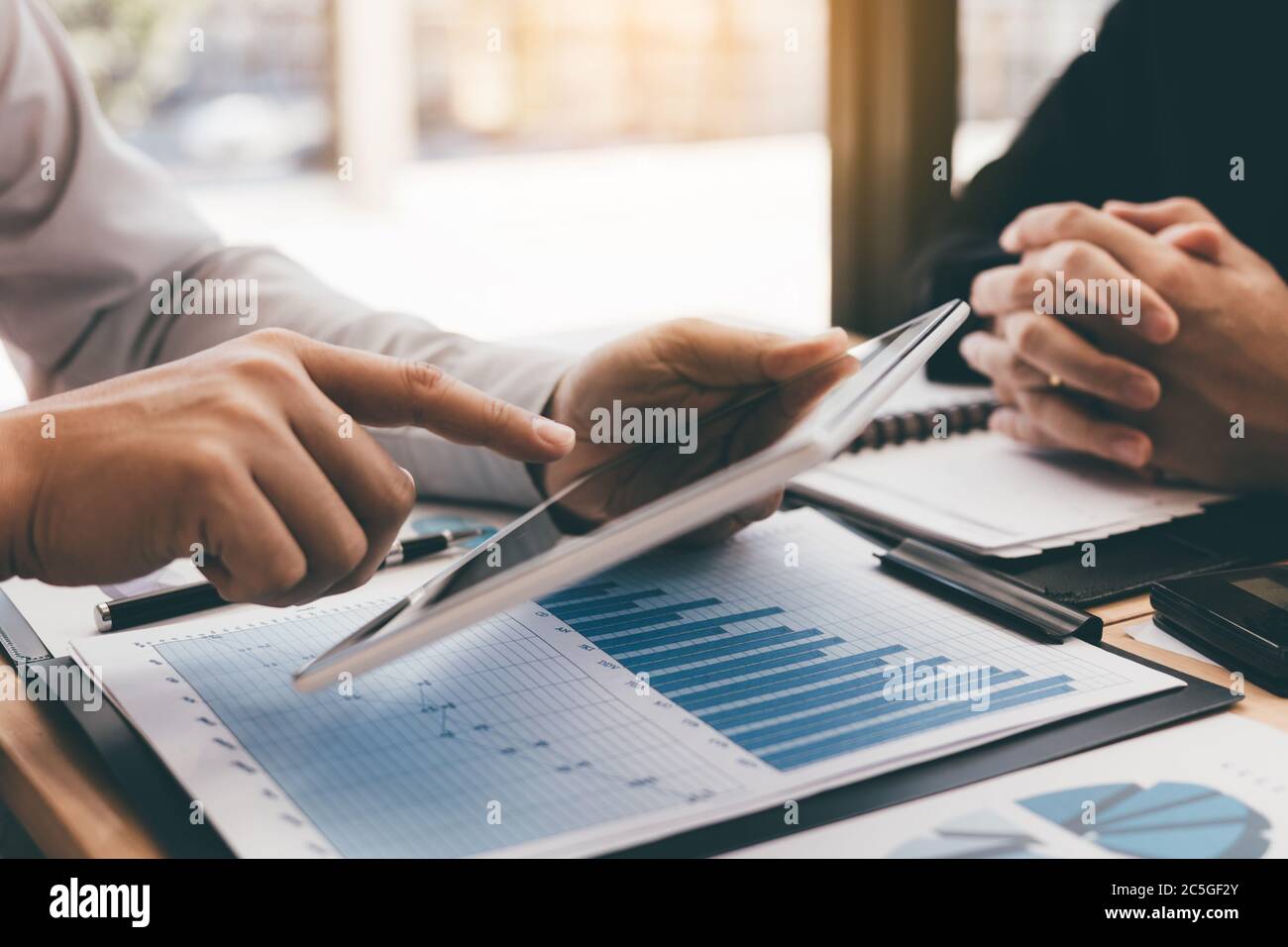 Managers are using tablet and explain the summary report to employee in ...