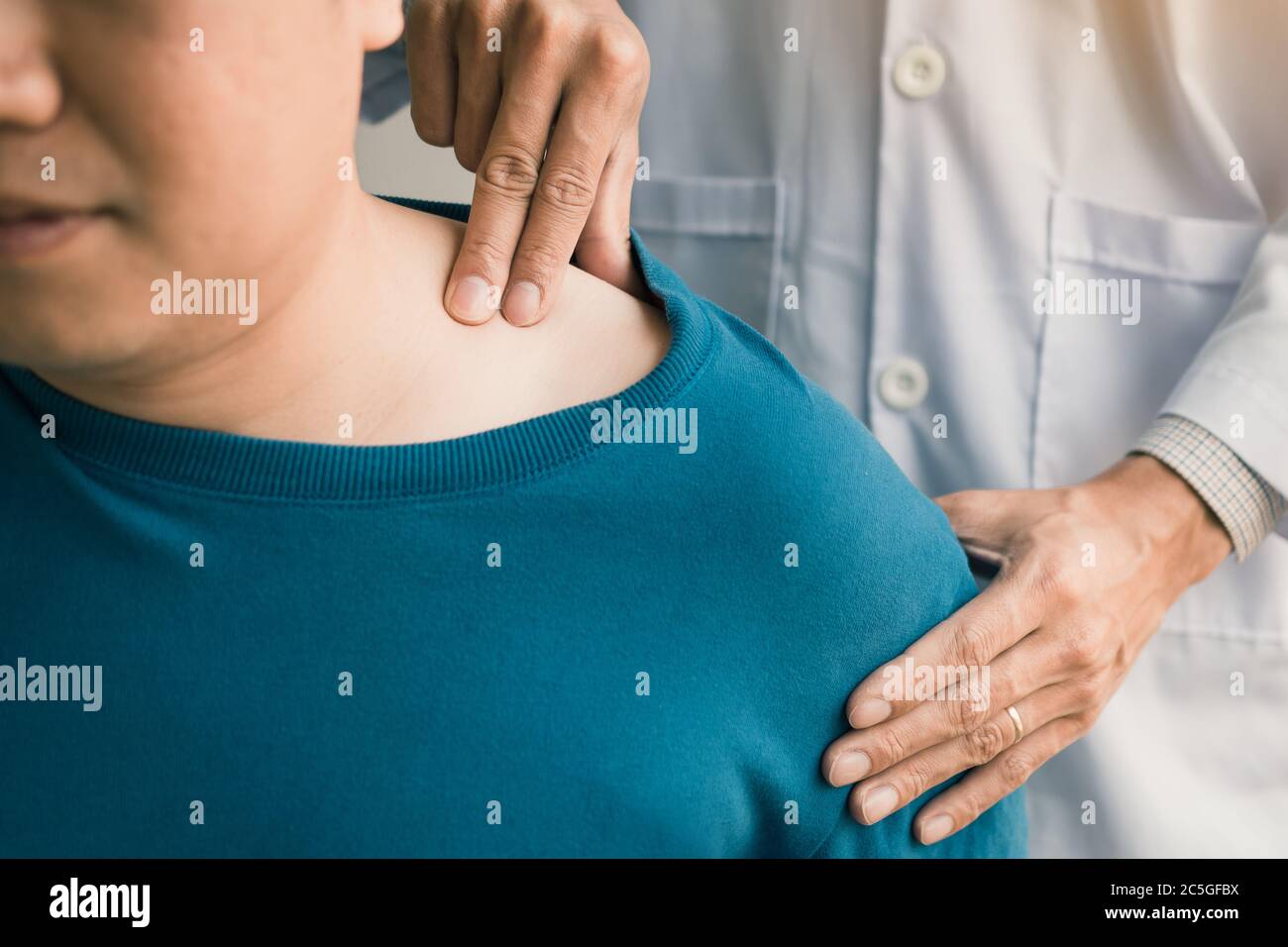 Physical therapists are using their hands to press the clavicle of the ...