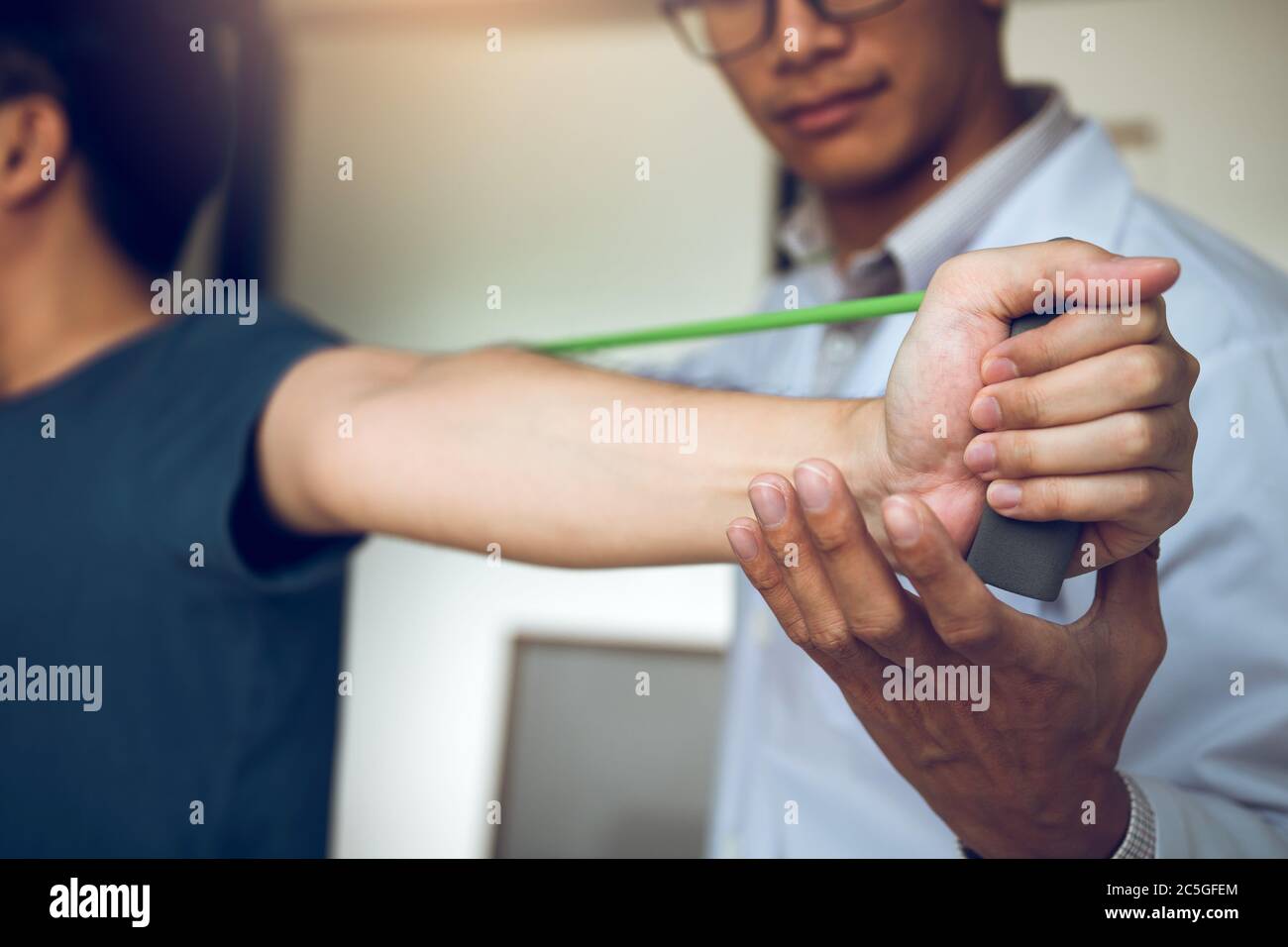 Asian male physical therapist descent working and helping to protect ...