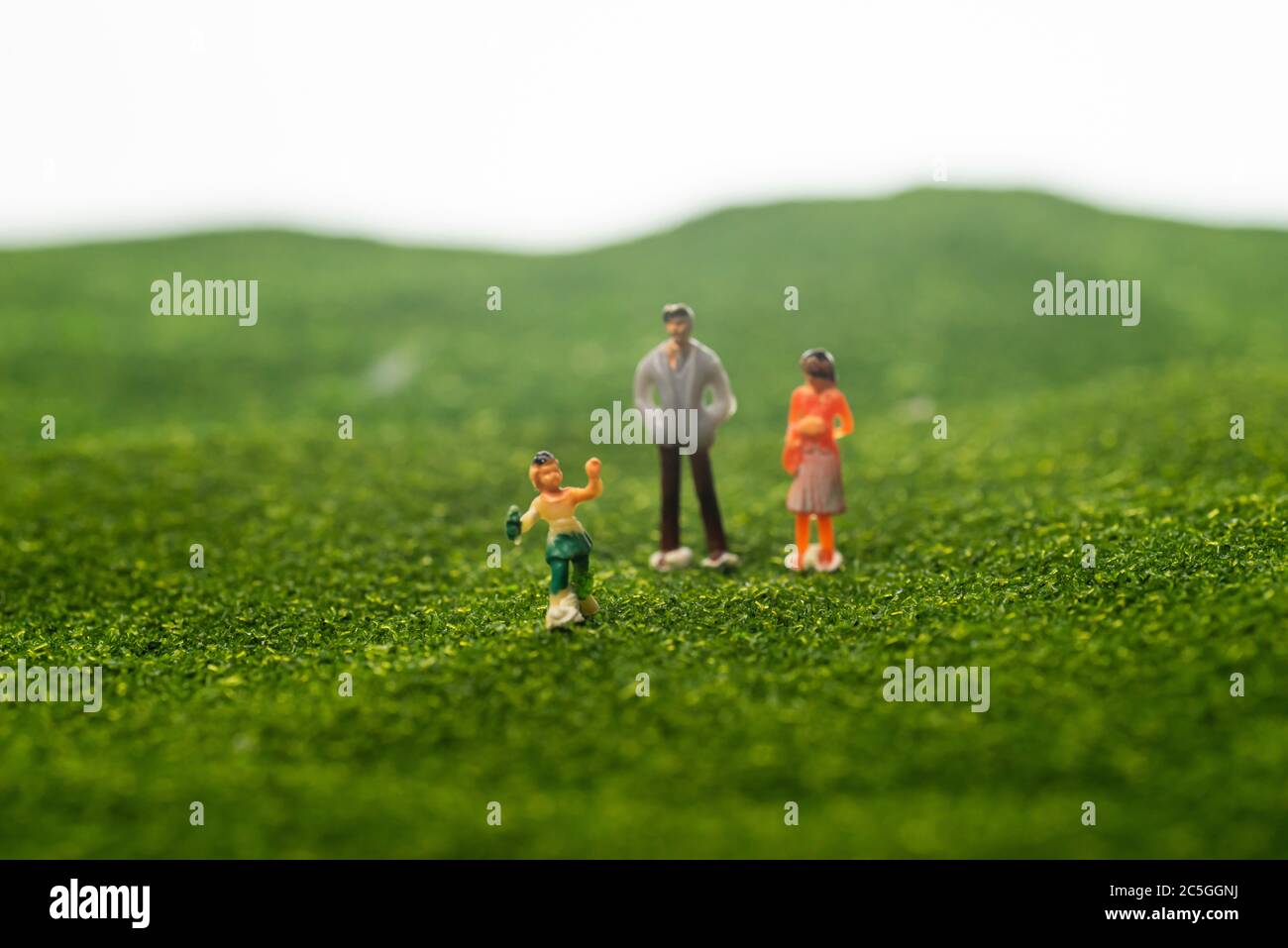 Happy family concept: Miniature family figurines on a park. Selective ...