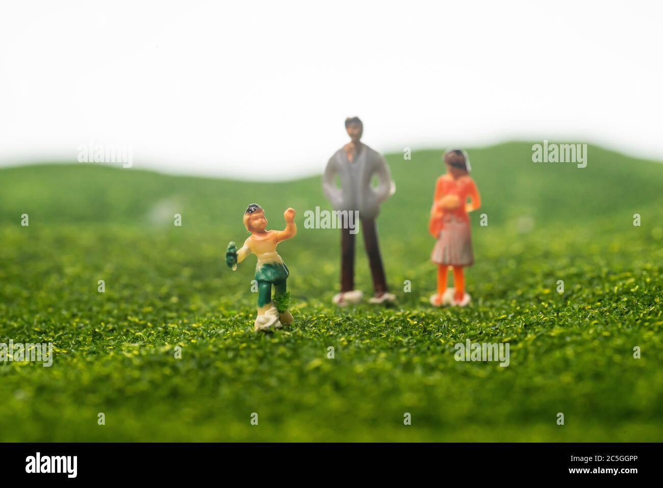 Happy family concept: Miniature family figurines on a park. Selective ...