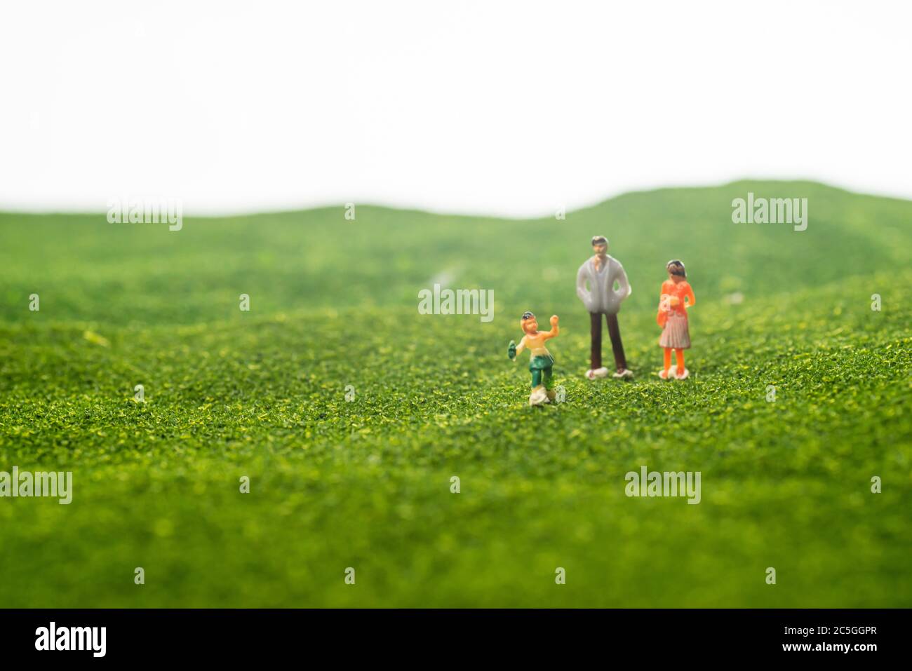 Happy family concept: Miniature family figurines on a park. Selective ...