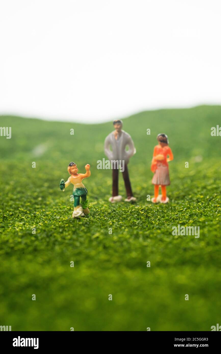 Happy family concept: Miniature family figurines on a park. Selective ...
