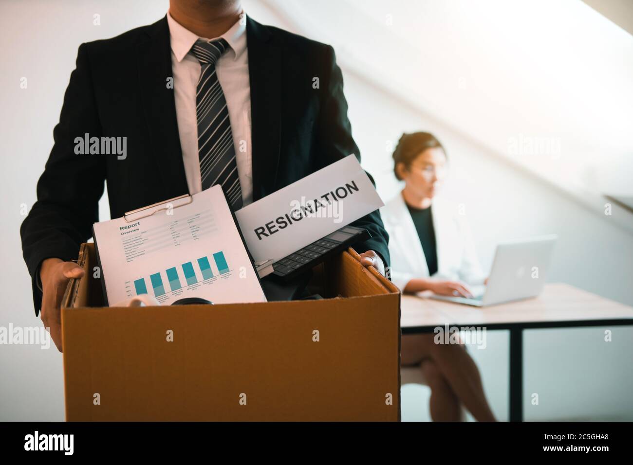 Front view with the male employee standing holding office supplies in ...