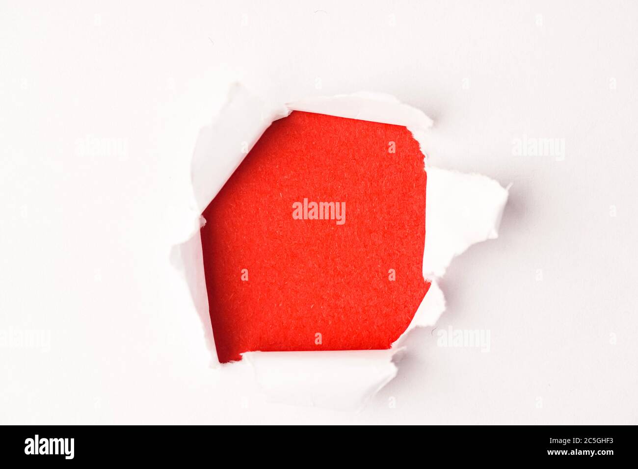 Hole in the paper with torn sides Stock Photo - Alamy