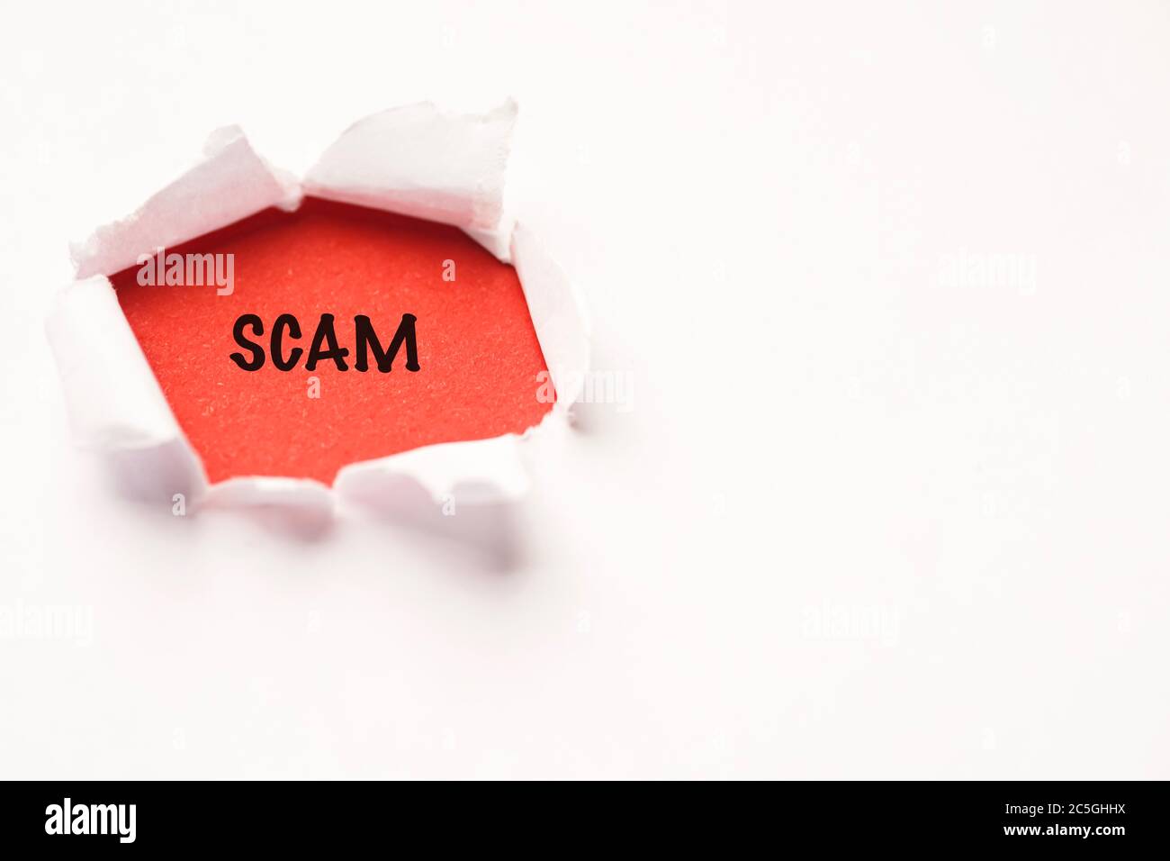 SCAM wording on a torn paper background Stock Photo - Alamy