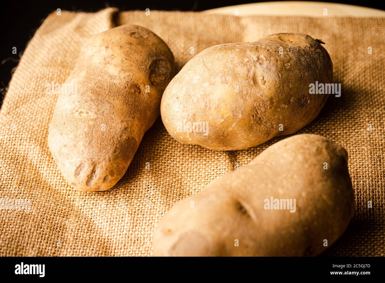 Fresh Potatoes on a rag with dark background Stock Photo - Alamy