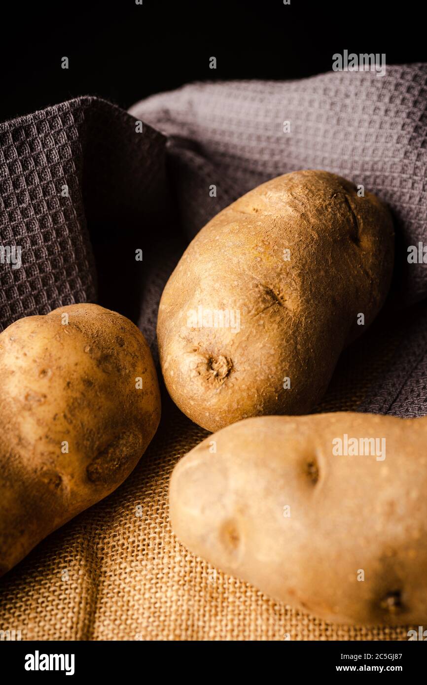 Fresh Potatoes on a rag with dark background Stock Photo - Alamy