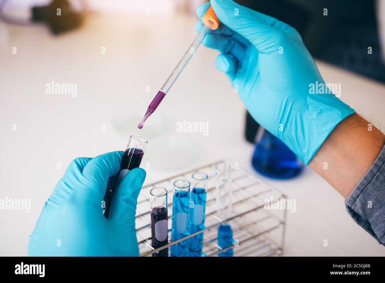 Chemist scientist conducts experiments by synthesising compounds with ...