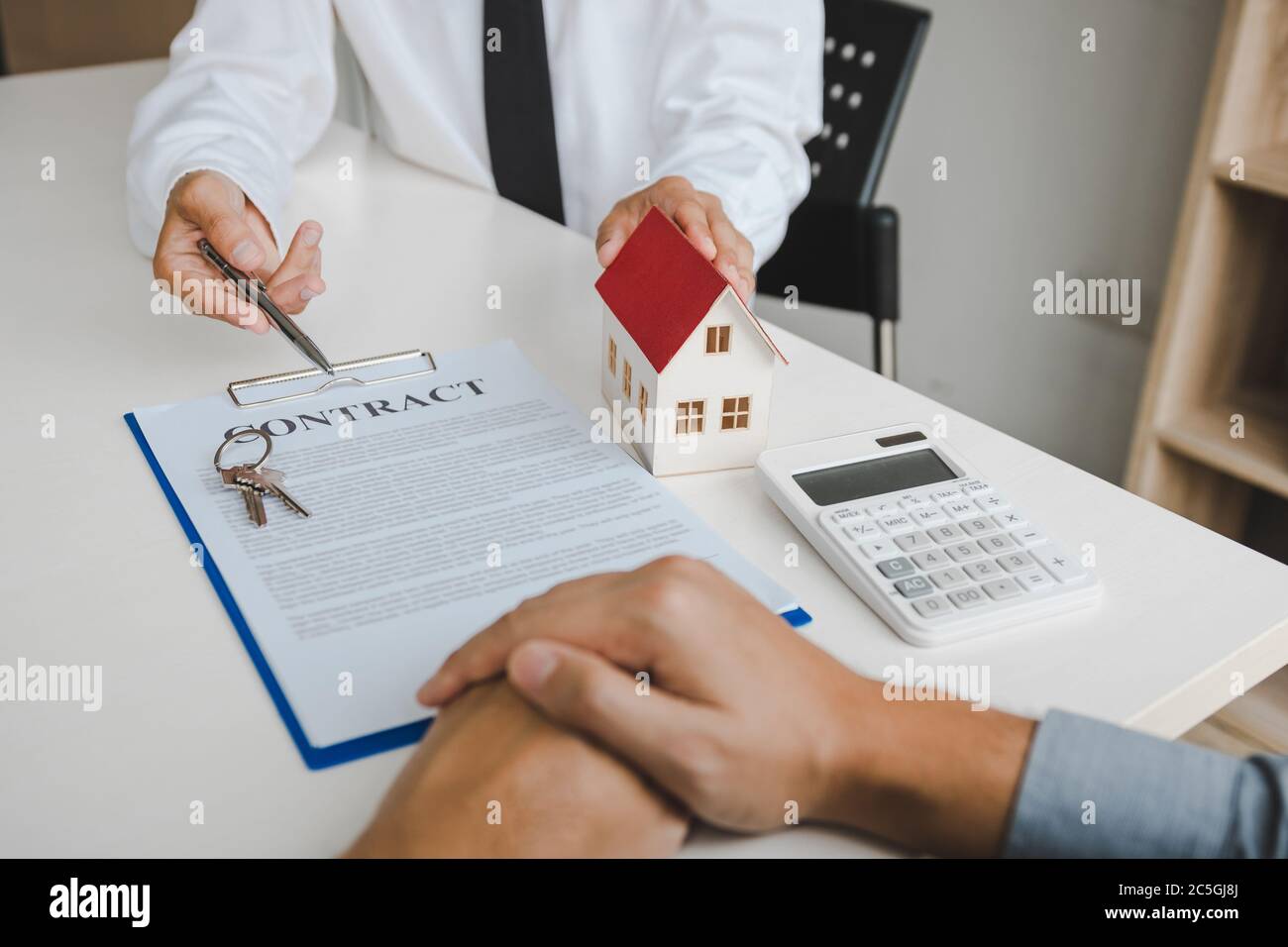 Salesman house brokers provide key to new homeowners in office Stock ...