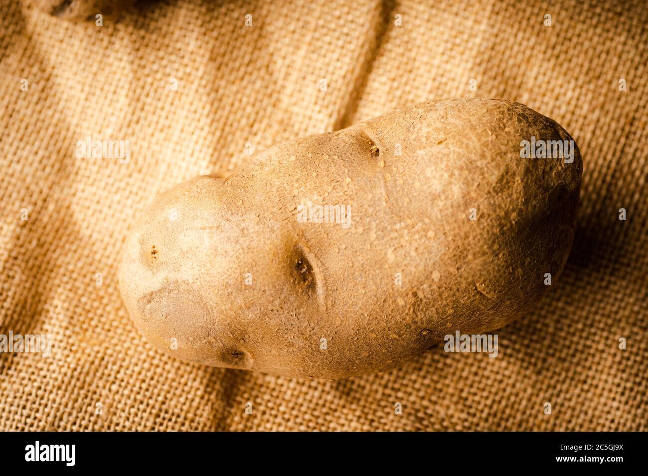 Fresh Potatoes on a rag with dark background Stock Photo - Alamy