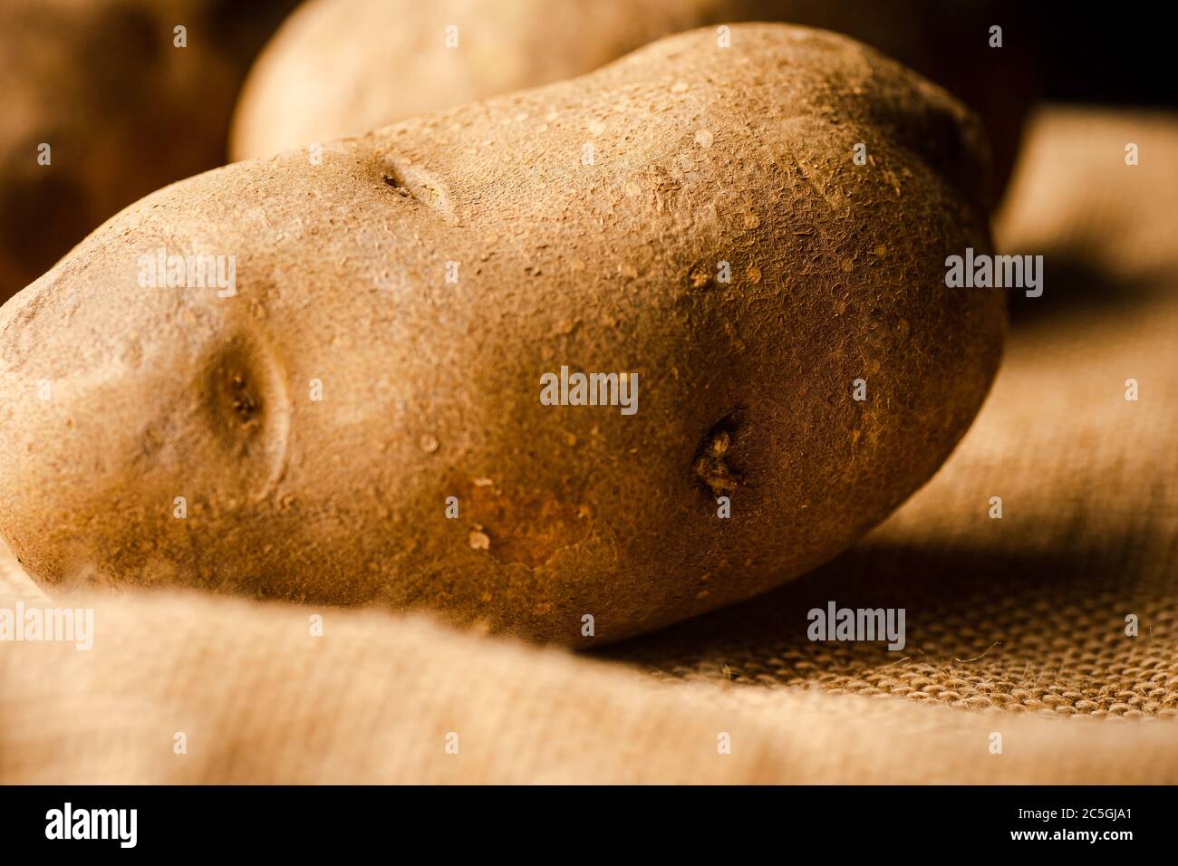 Fresh Potatoes on a rag with dark background Stock Photo - Alamy