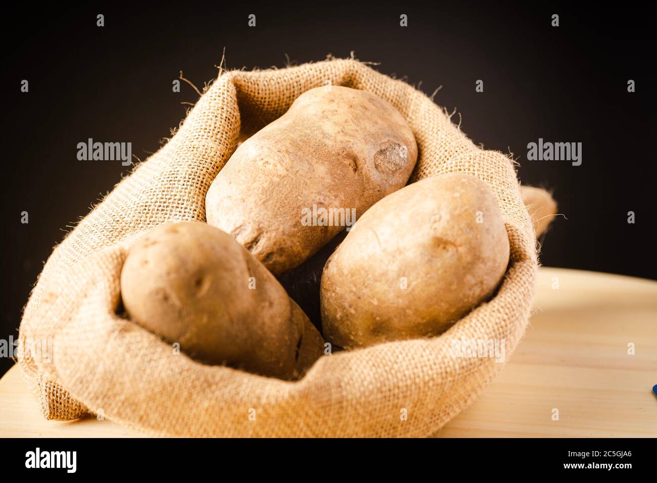 Fresh Potatoes on a rag with dark background Stock Photo - Alamy
