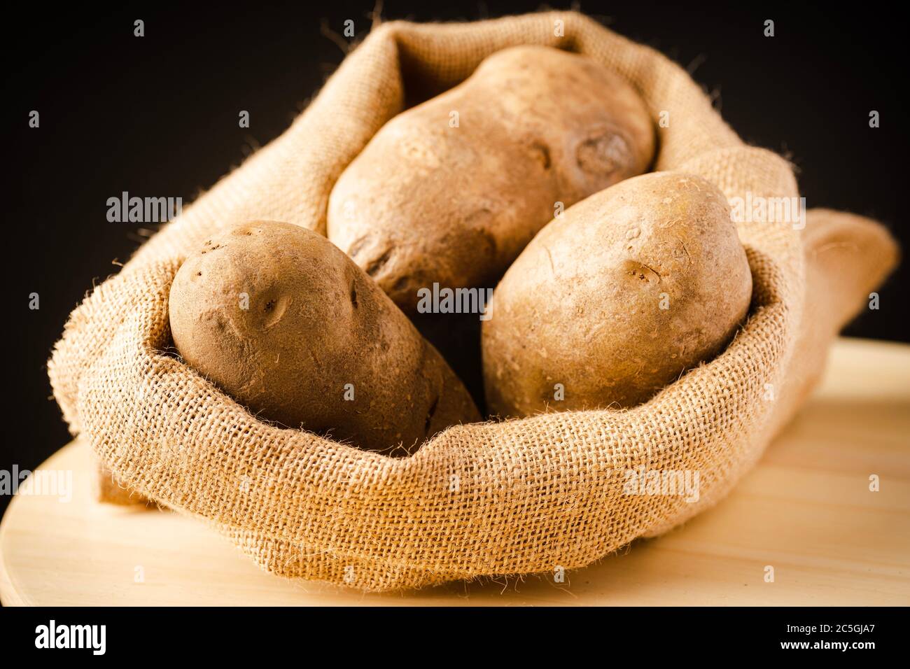 Fresh Potatoes on a rag with dark background Stock Photo - Alamy