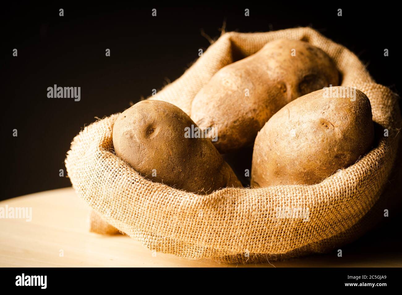 Fresh Potatoes on a rag with dark background Stock Photo - Alamy