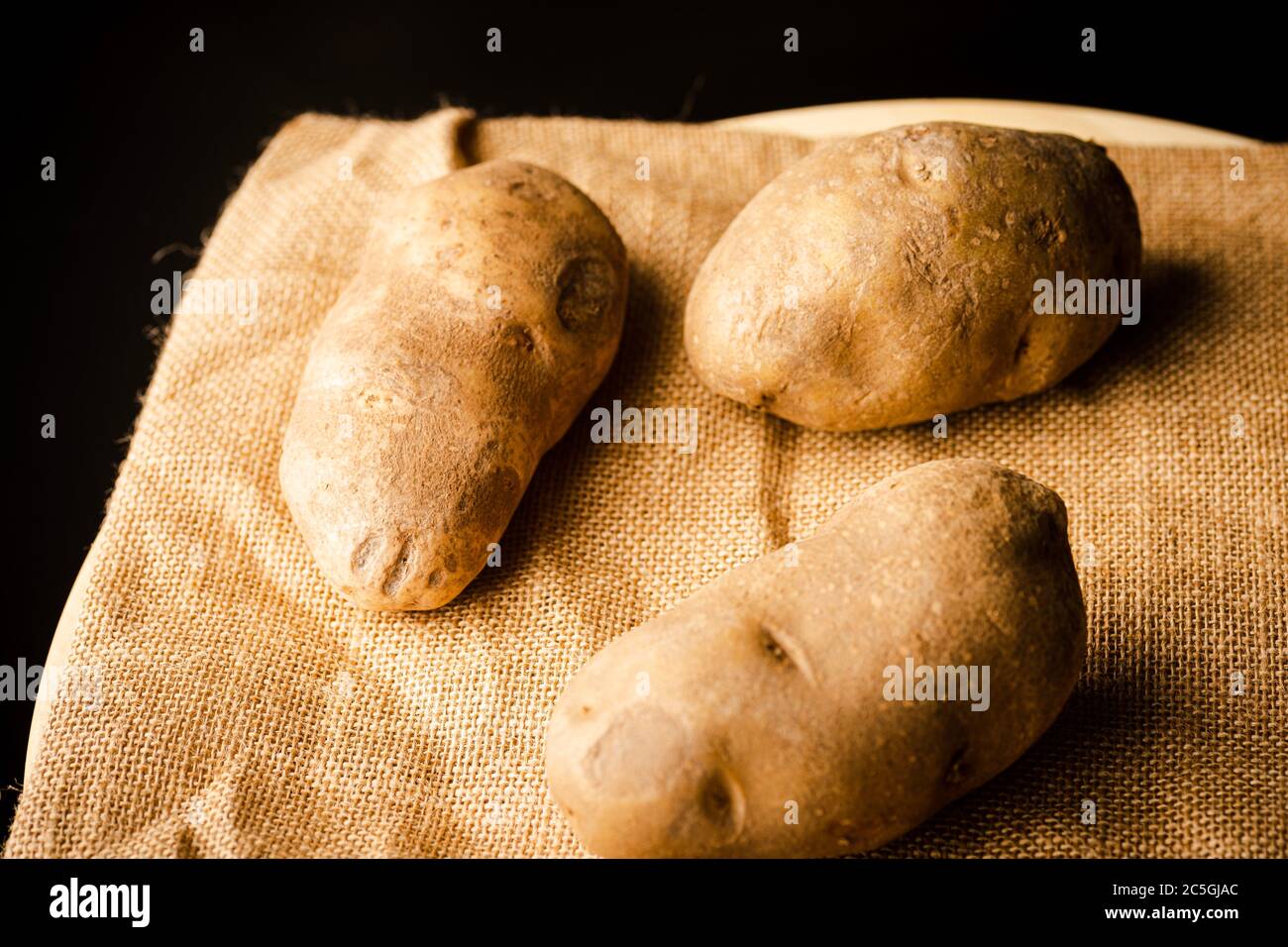 Fresh Potatoes on a rag with dark background Stock Photo - Alamy