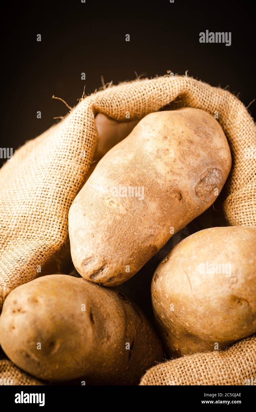 Fresh Potatoes on a rag with dark background Stock Photo - Alamy
