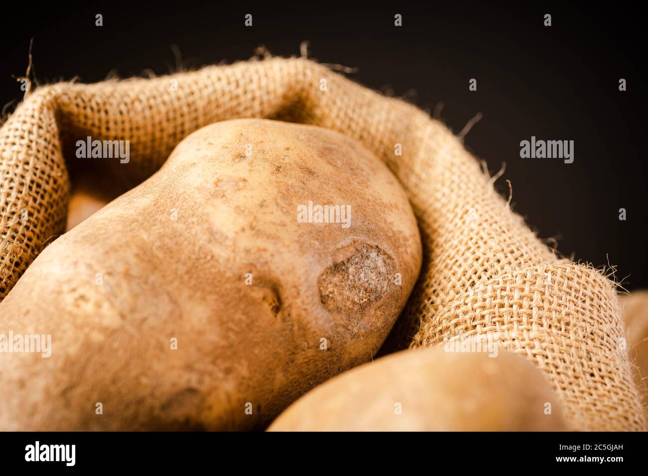Fresh Potatoes on a rag with dark background Stock Photo - Alamy