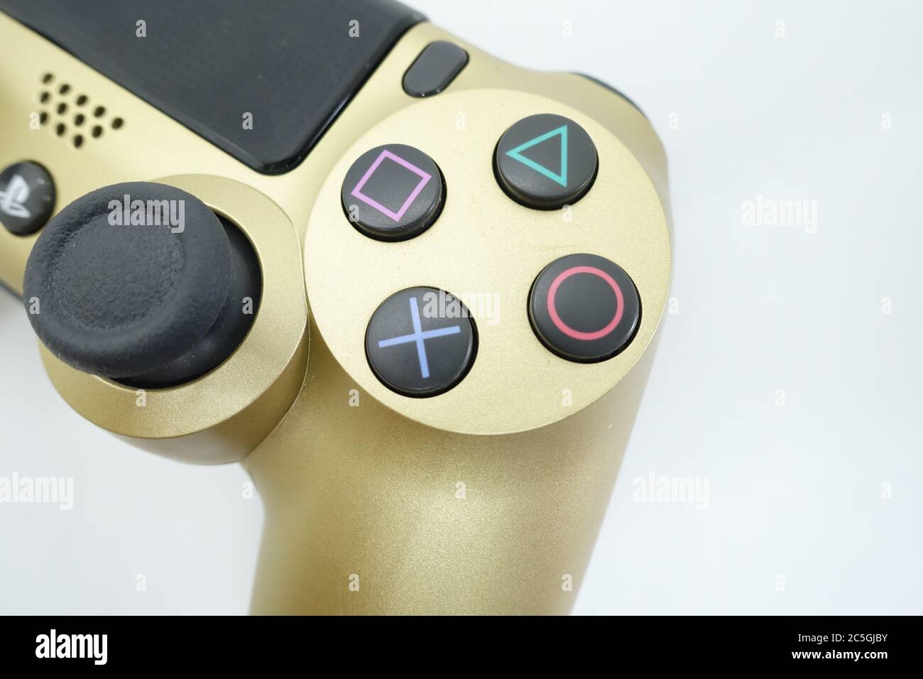 A gold colour Playstation 4 DS4 controller against isolated white ...