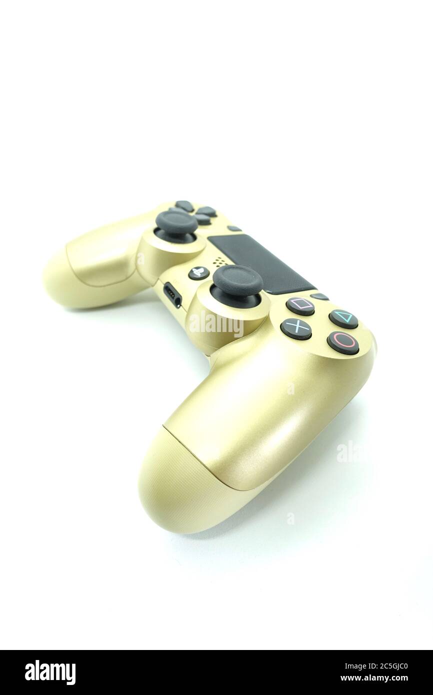 A gold colour Playstation 4 DS4 controller against isolated white ...