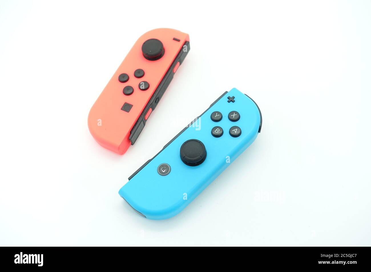 A neon blue and neon red Nintendo Switch joycon against isolated white ...