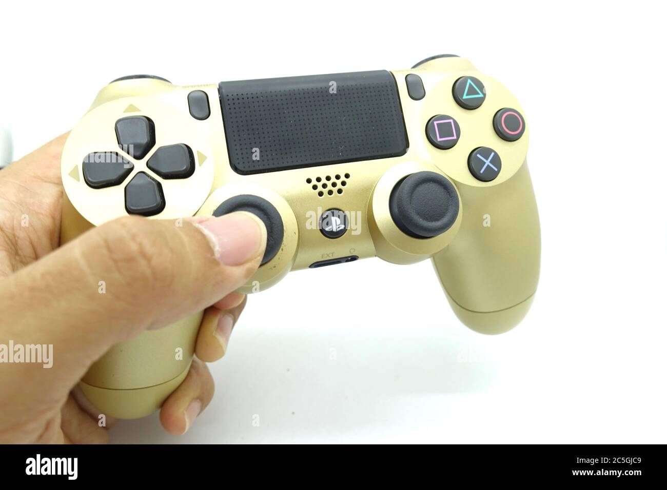 A gold colour Playstation 4 DS4 controller against isolated white ...
