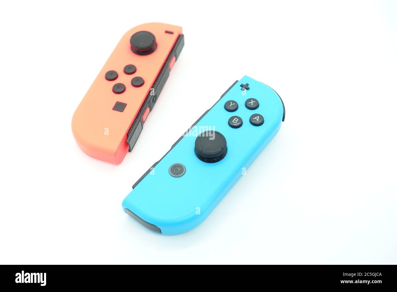 A neon blue and neon red Nintendo Switch joycon against isolated white ...