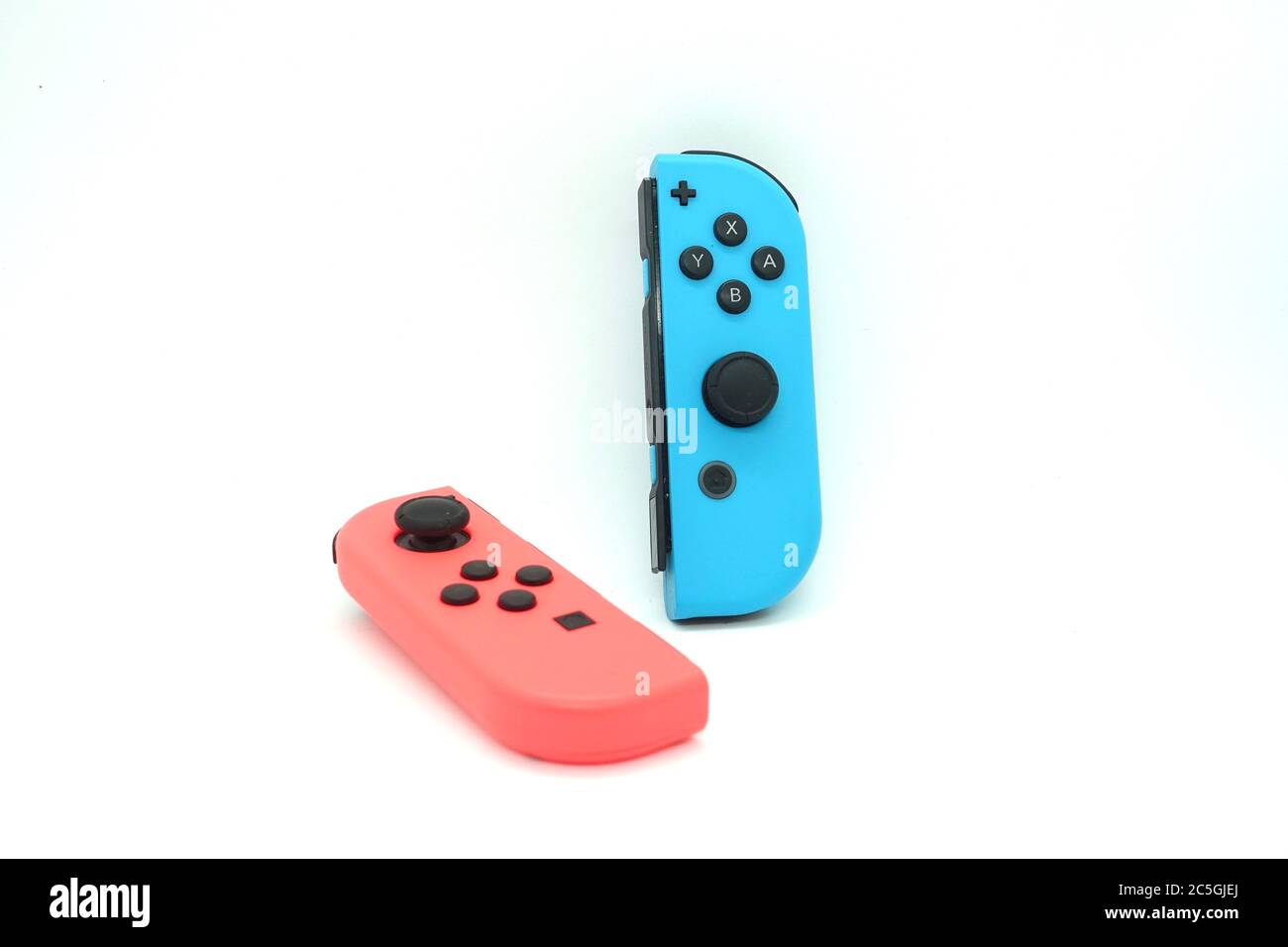 A neon blue and neon red Nintendo Switch joycon against isolated white ...
