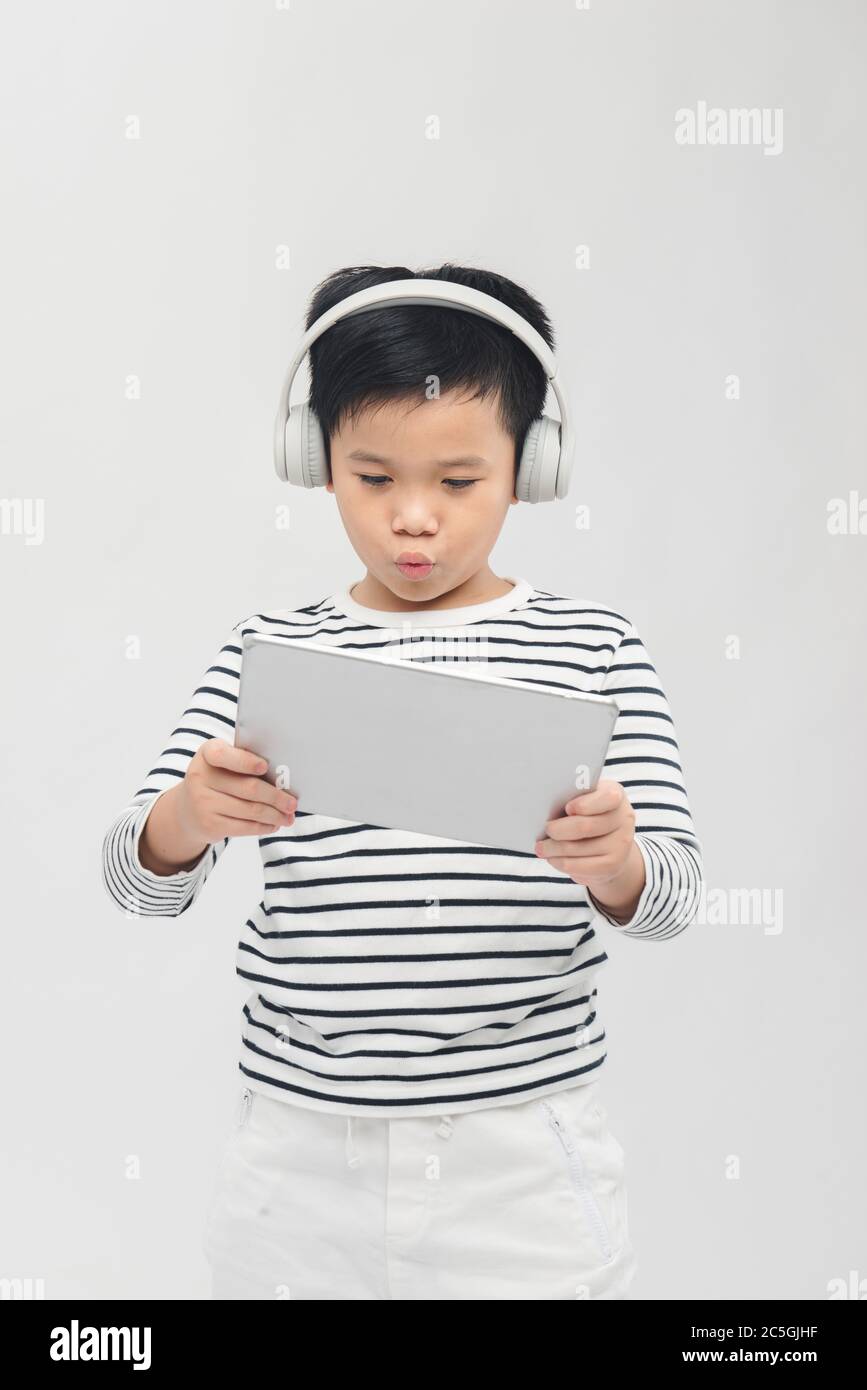Asian boy laying tablet computer with headset Stock Photo - Alamy