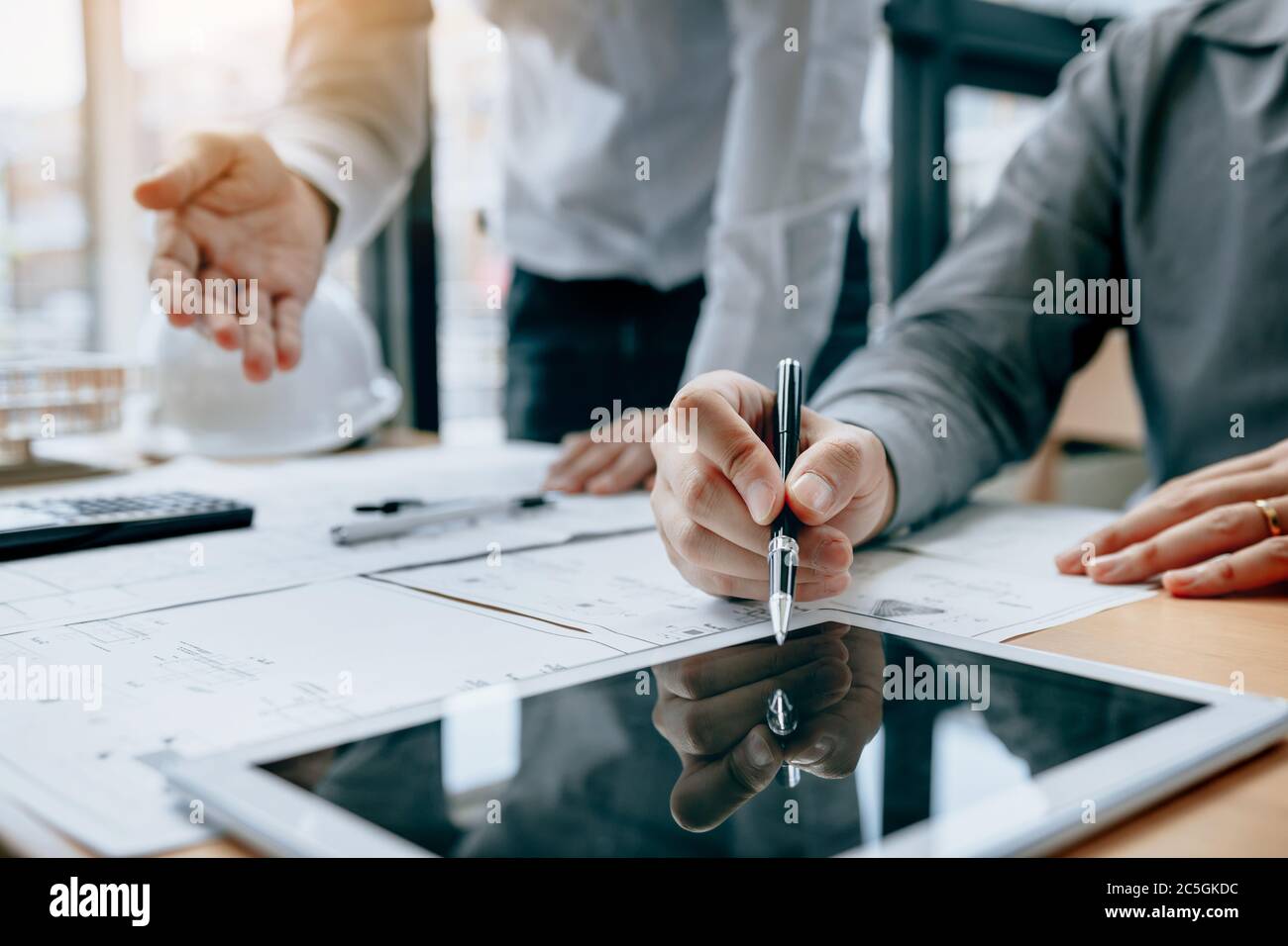 Two engineering working together and using digital tablet looking ...